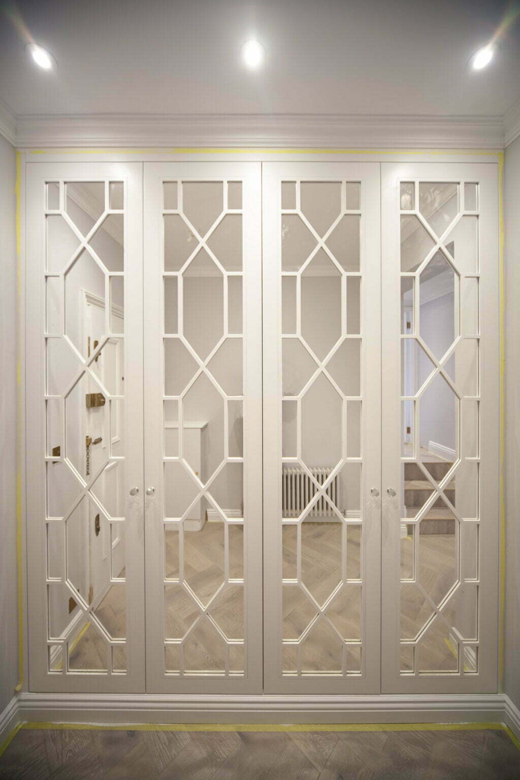 Prisma fitted mirrored wardrobes with lacquered fretwork doors London